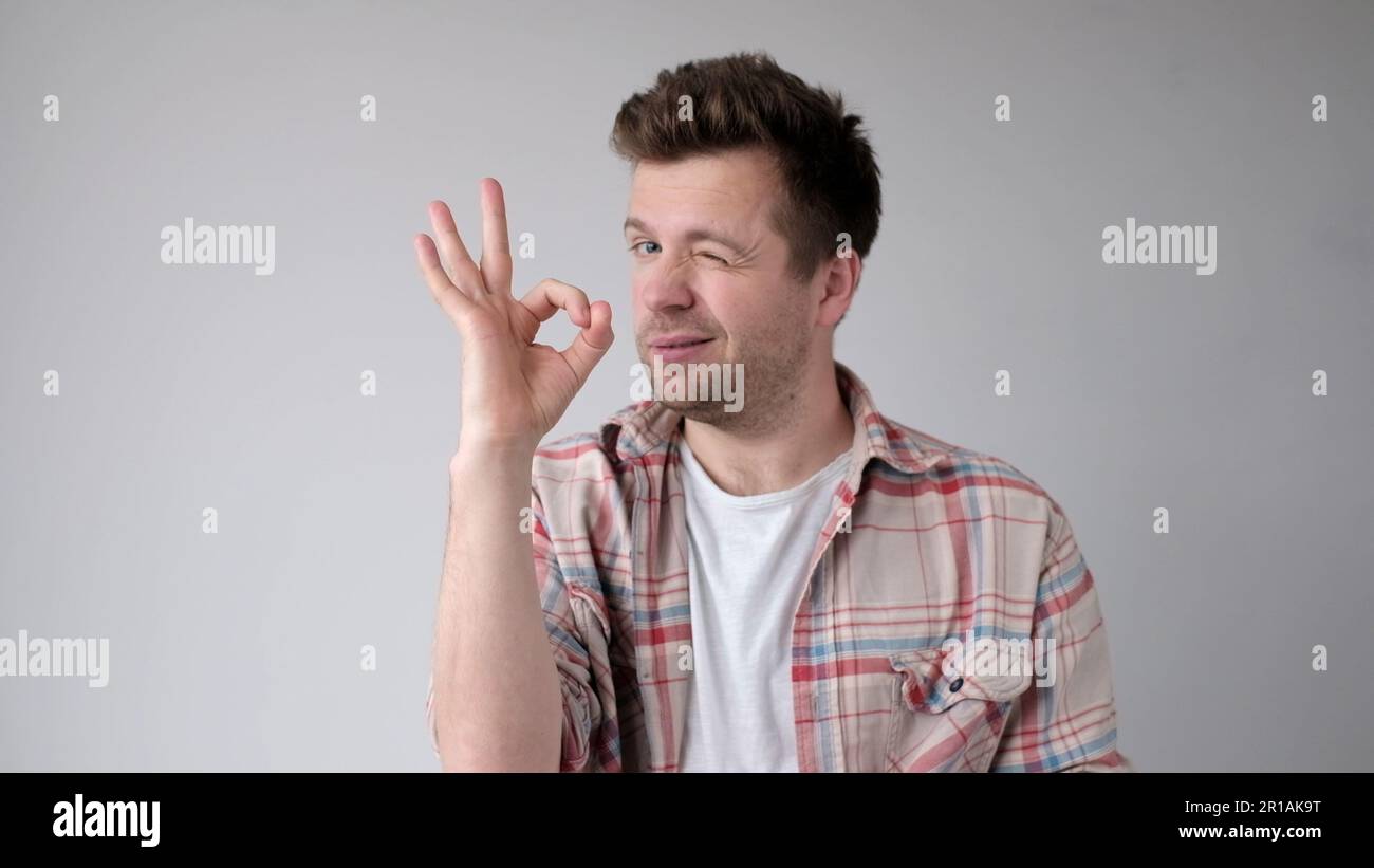 The European young man shows the okay gesture, saying everything is ...