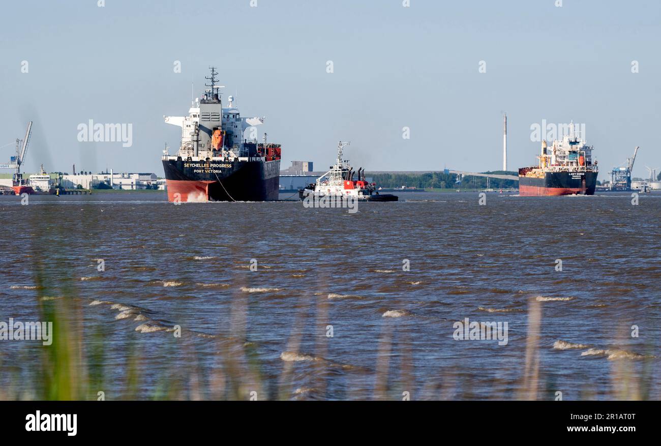 Nordenham, Germany. 12th May, 2023. Two cargo ships and a tugboat are sailing on the Weser River ...