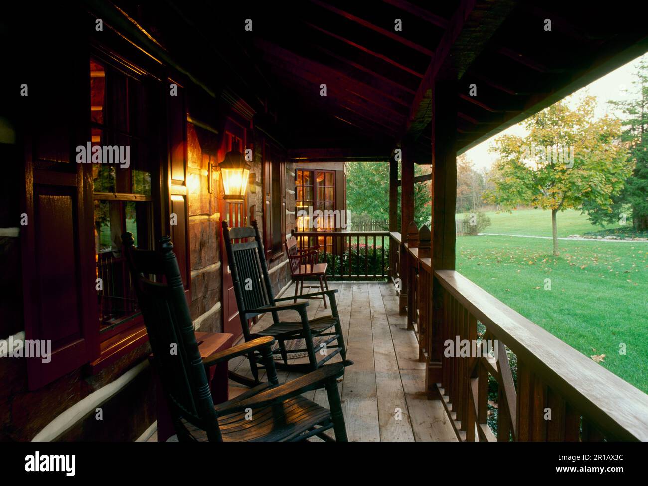 Porch of a log cabin at twilight with wide board floors and rocking ...