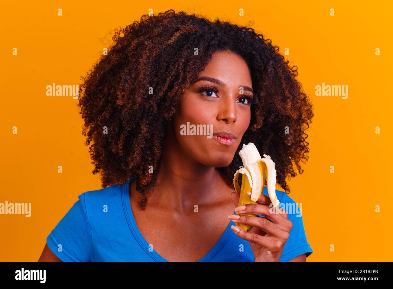 young afro girl eating banana. Health concept. Healthy eating Stock ...