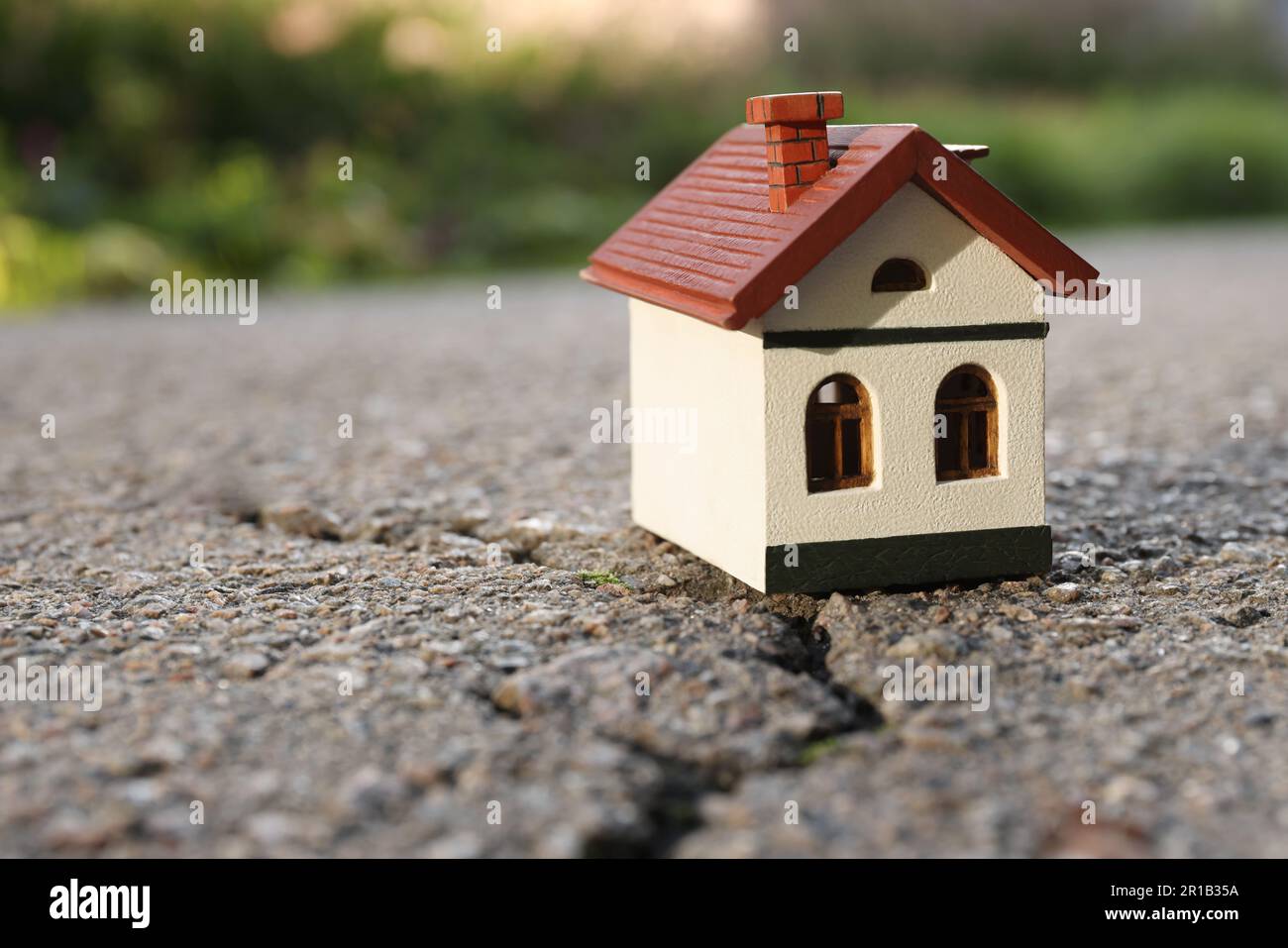 Wooden house model on cracked asphalt. Earthquake disaster Stock Photo ...