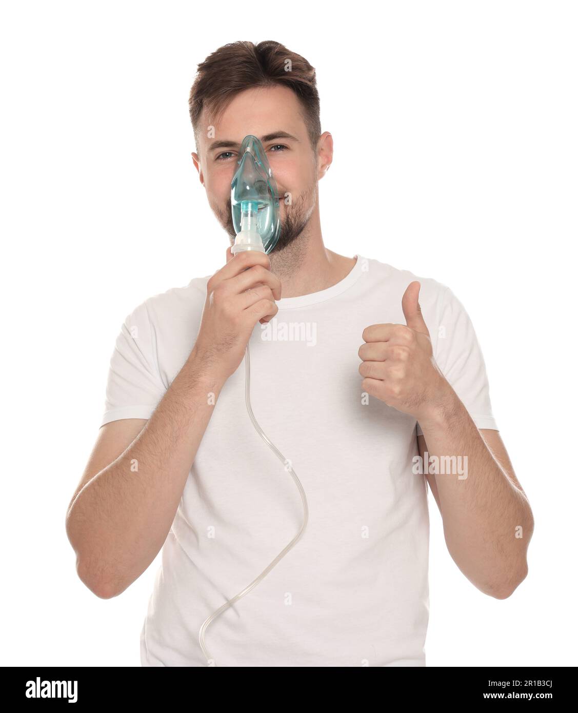 Man using nebulizer for inhalation and showing thumb up on white ...