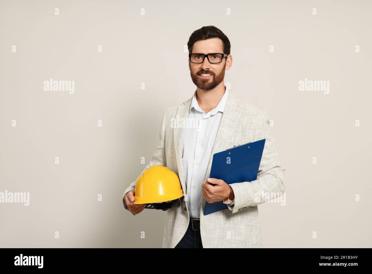 Professional engineer with hard hat and clipboard on white background ...