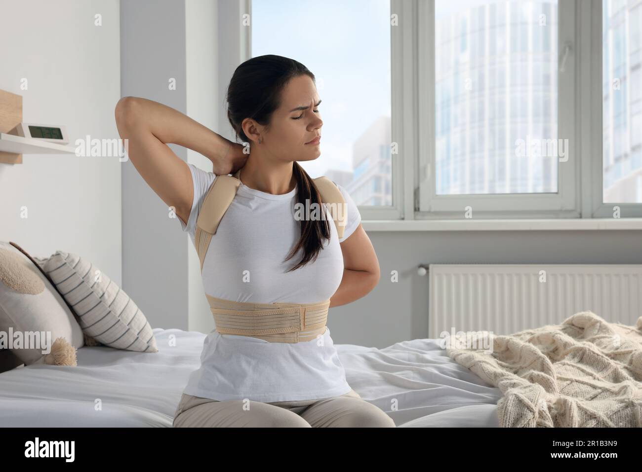 Woman with orthopedic corset sitting in bedroom Stock Photo - Alamy