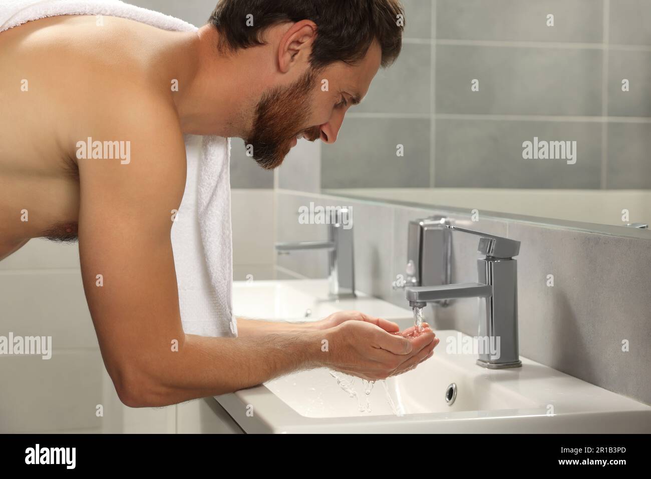 Handsome man washing face in bathroom, closeup Stock Photo - Alamy