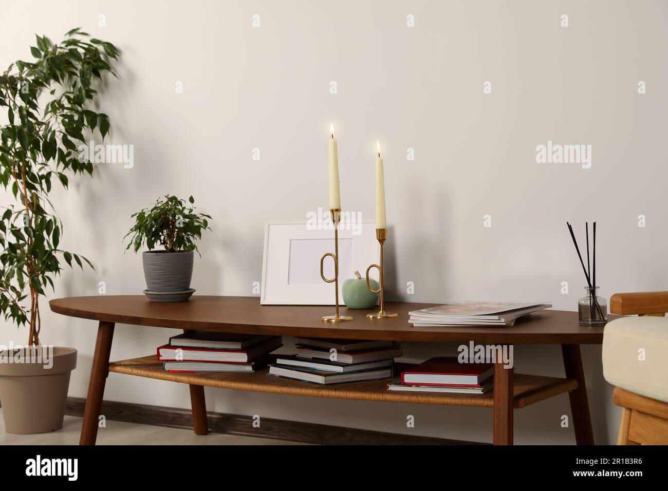 Wooden table with decorative elements near light wall in room. Interior ...
