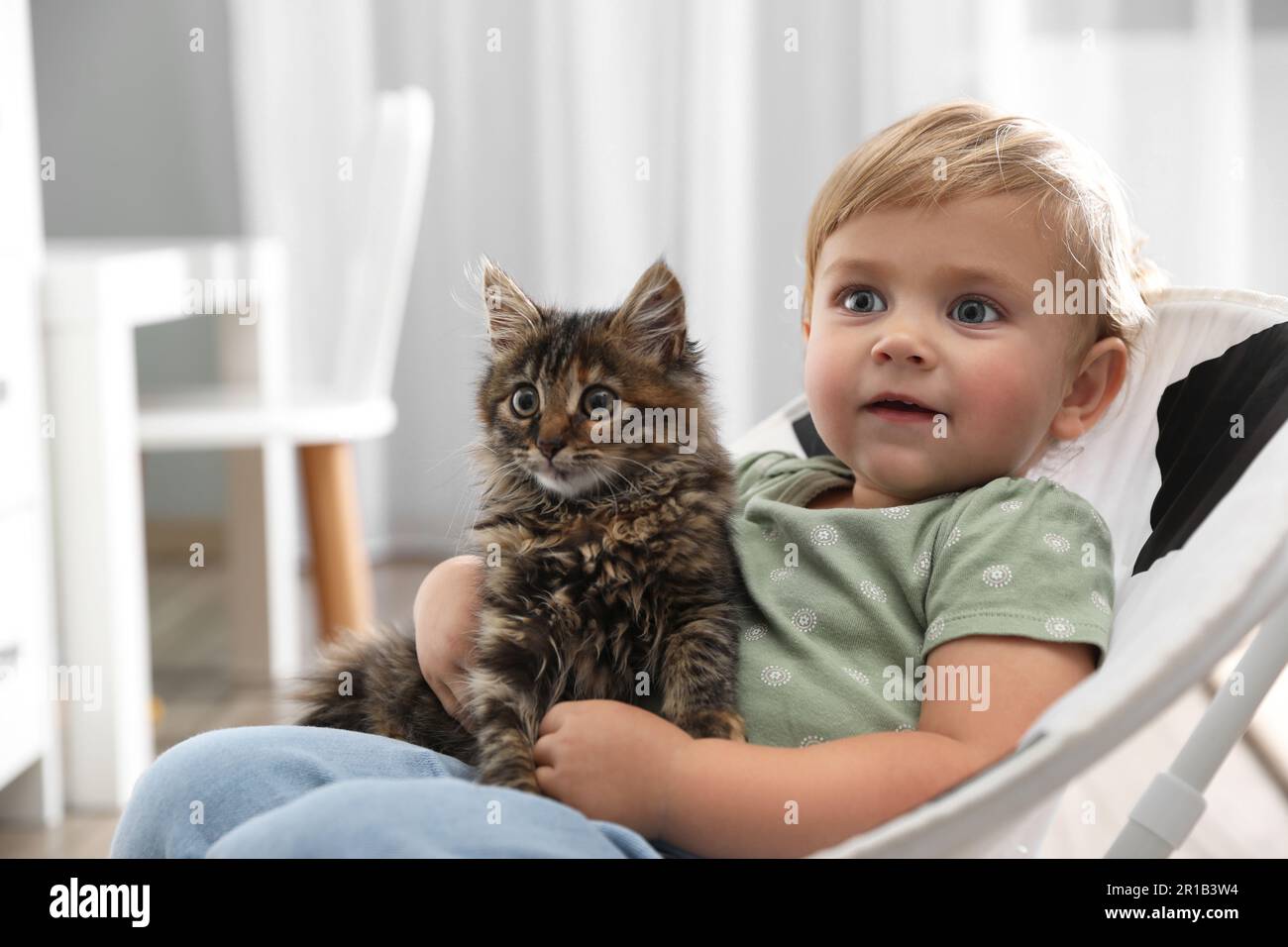 Cute little child with adorable pet sitting in armchair at home Stock ...