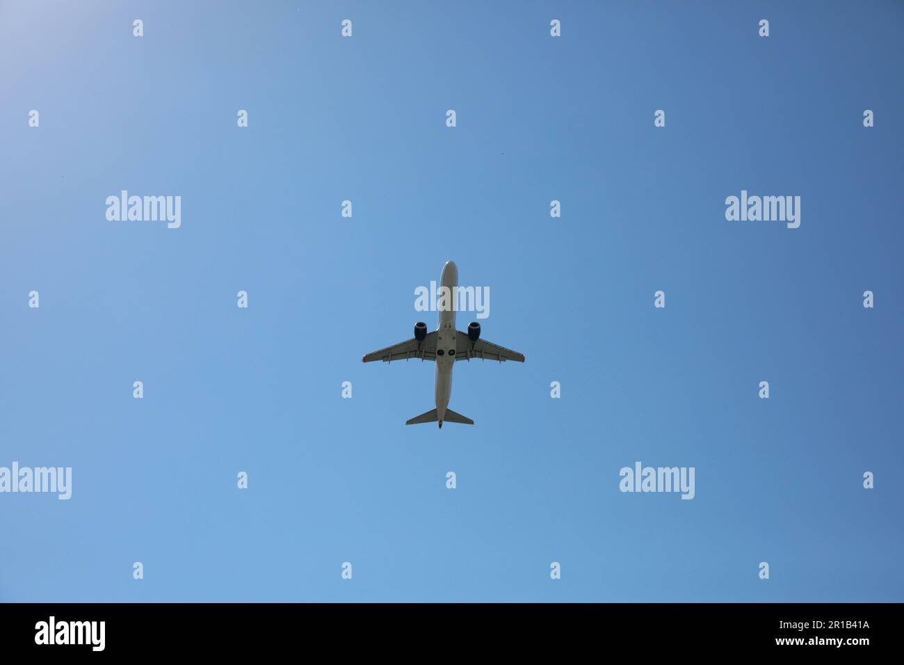 Modern white airplane flying in sky, bottom view Stock Photo - Alamy
