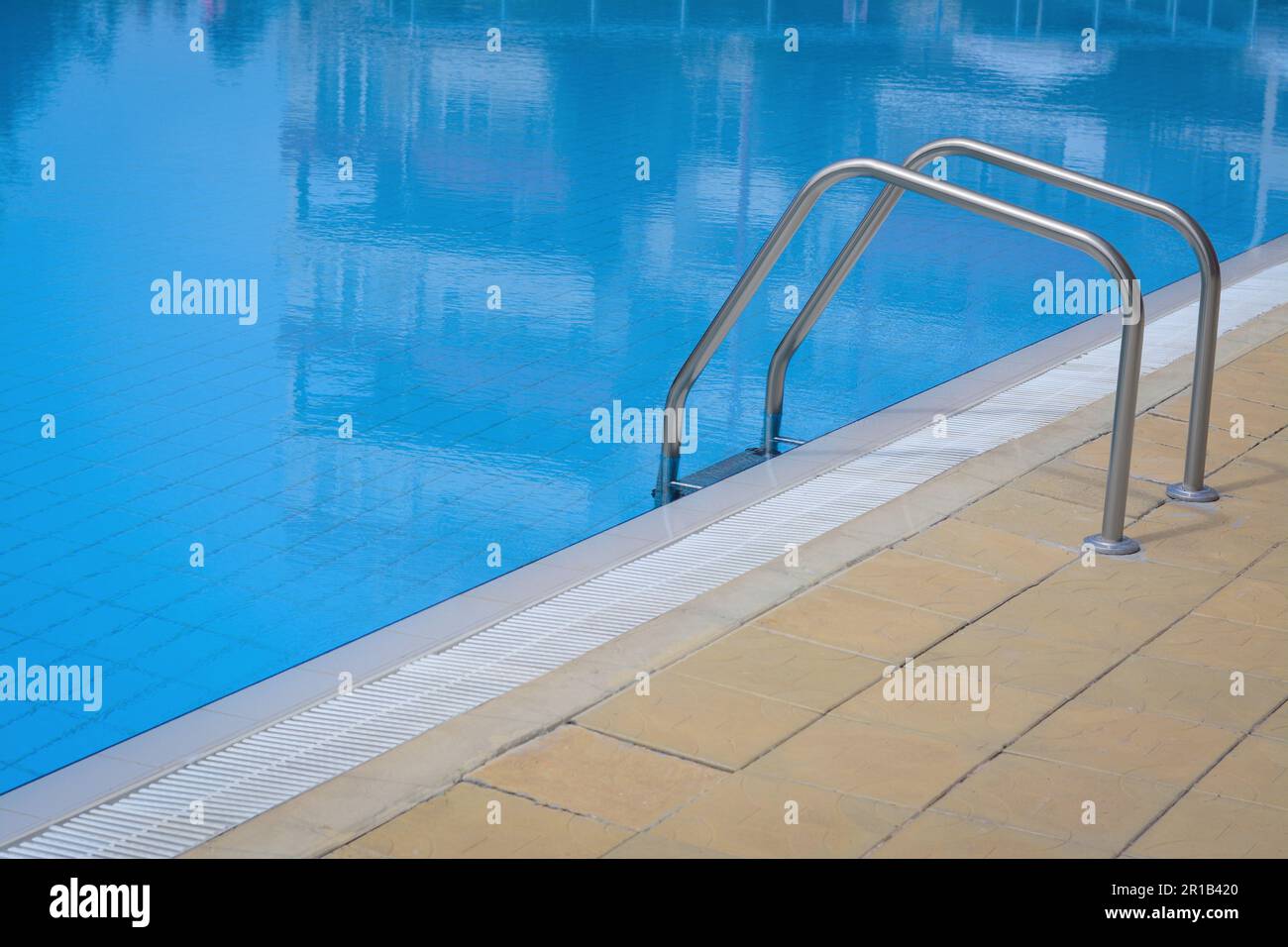 Outdoor swimming pool with handrails at resort on sunny day Stock Photo ...
