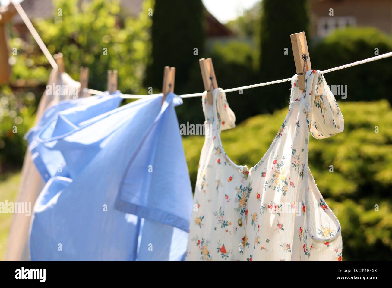 Clean clothes hanging on washing line in garden. Drying laundry Stock ...