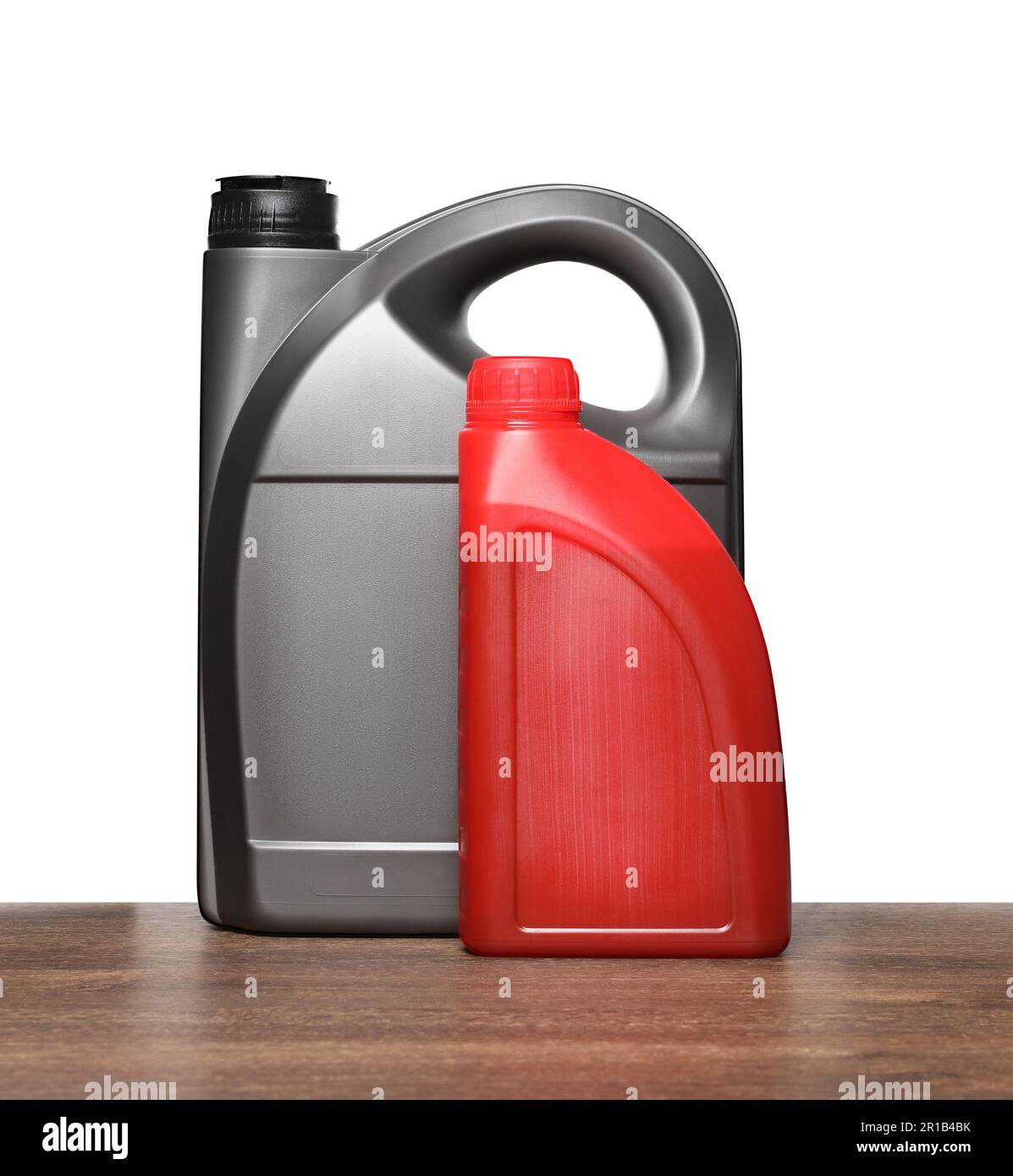 Motor oil in different containers on wooden table against white ...