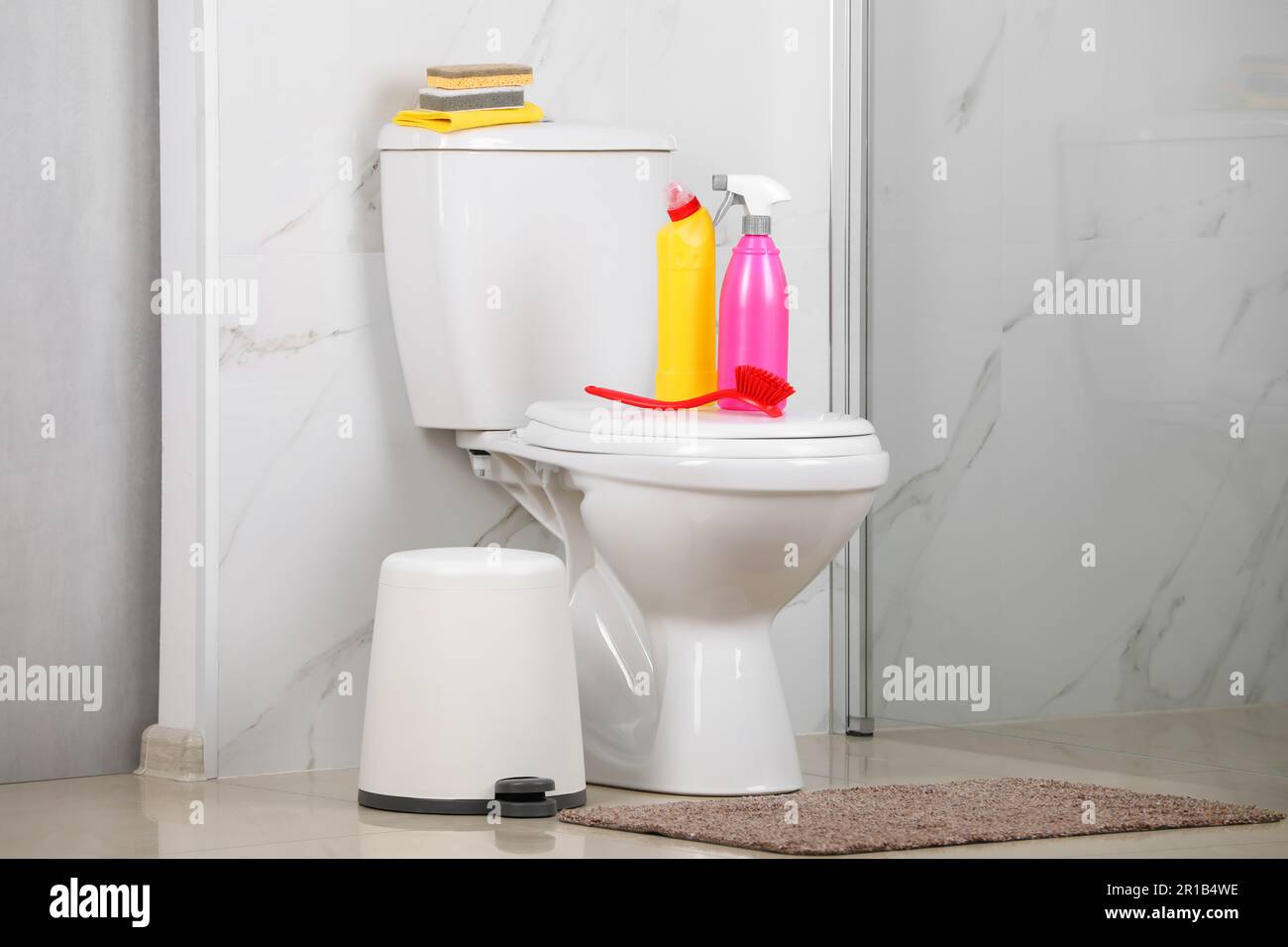 Cleaning supplies on toilet bowl in bathroom Stock Photo - Alamy