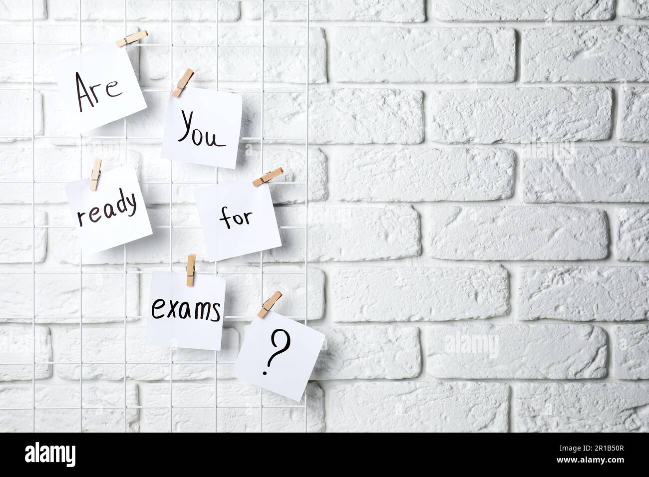 Notes with phrase Are you ready for exams hanging on white brick wall ...