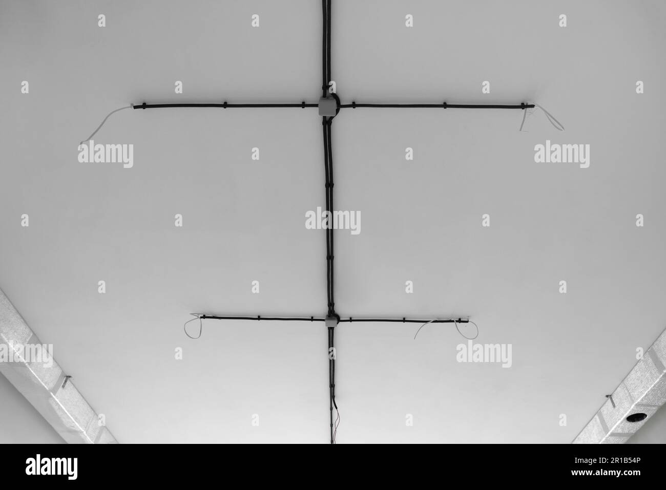 Black cables on white ceiling. Wiring system Stock Photo - Alamy