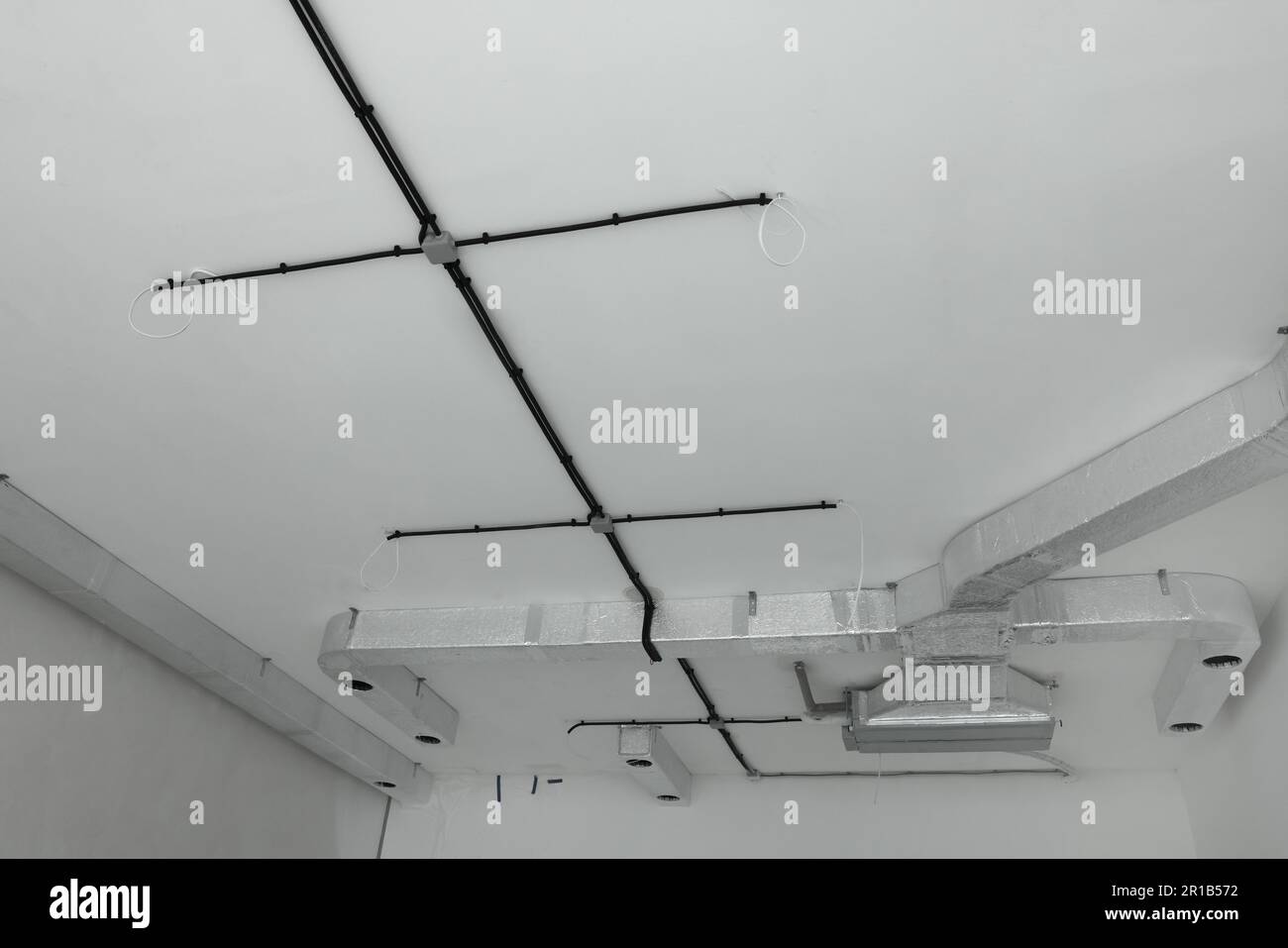 Black cables and ventilation system on white ceiling Stock Photo - Alamy