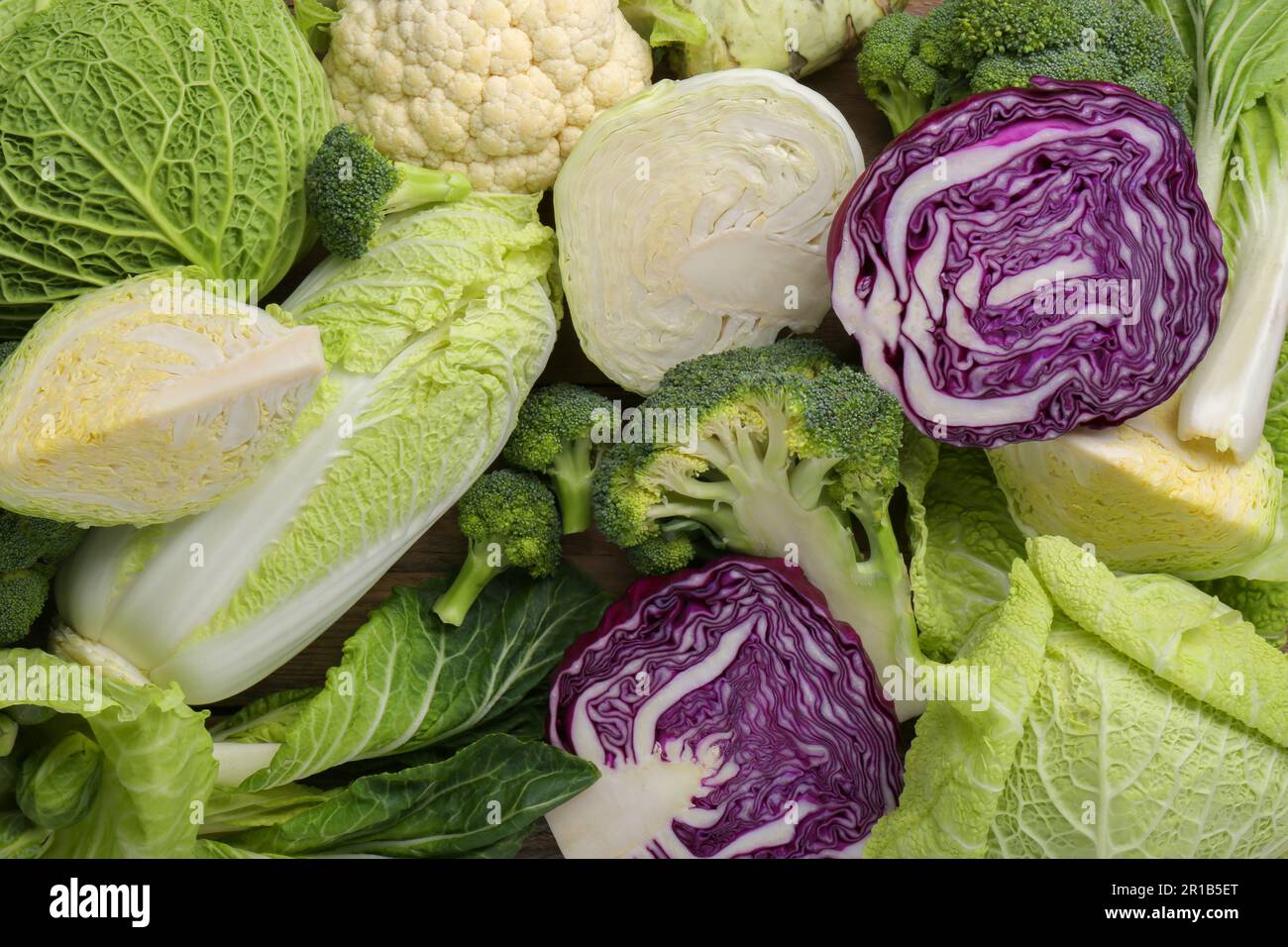 Different whole and sliced types of cabbage as background, top view ...