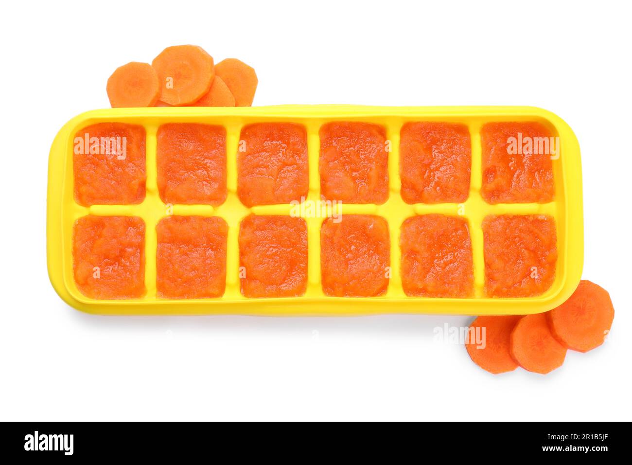 Carrot puree in ice cube tray isolated on white, top view. Ready for ...