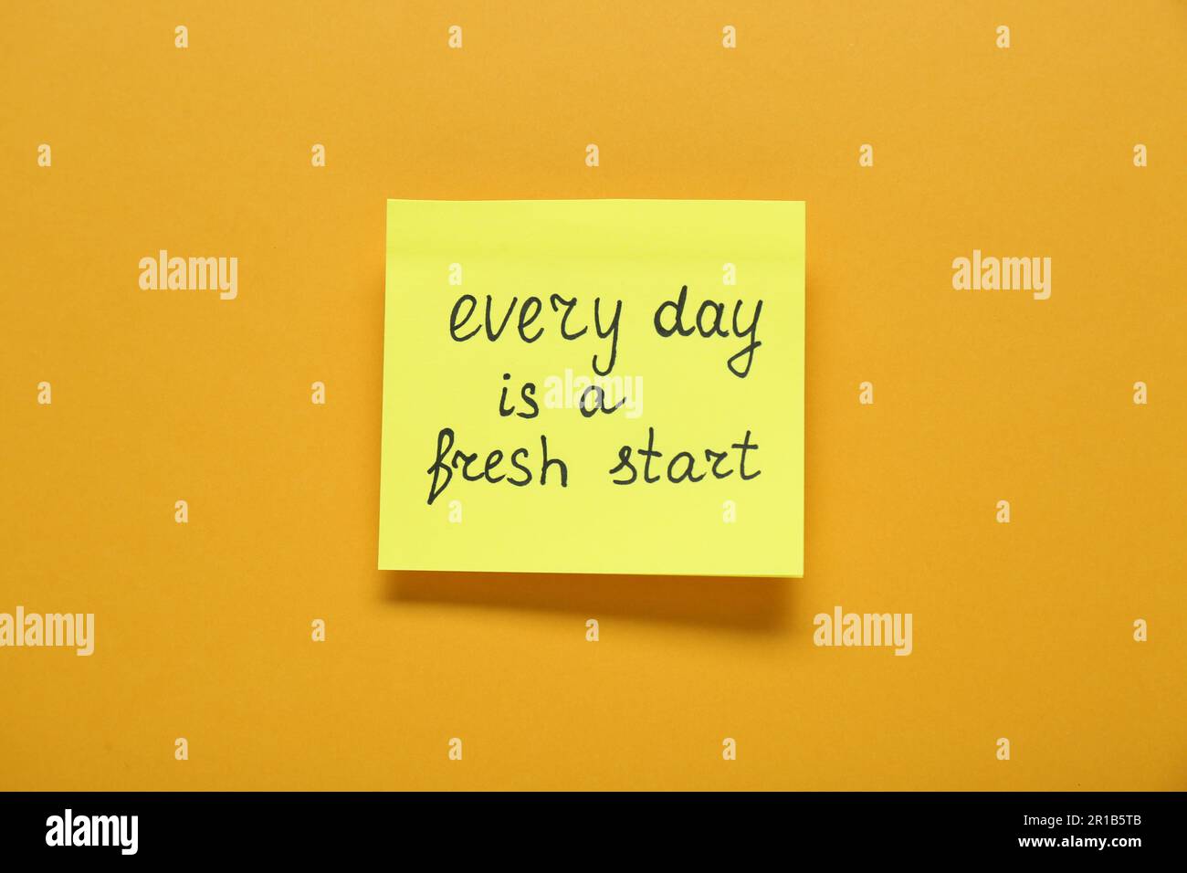 Note with phrase Every Day Is A Fresh Start on orange background, top ...