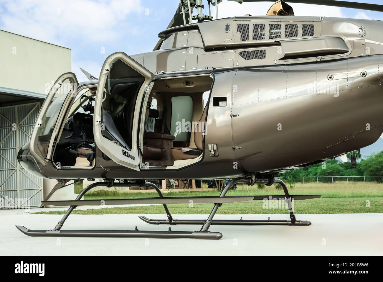 New helicopter with open cabin doors on helipad outdoors Stock Photo ...