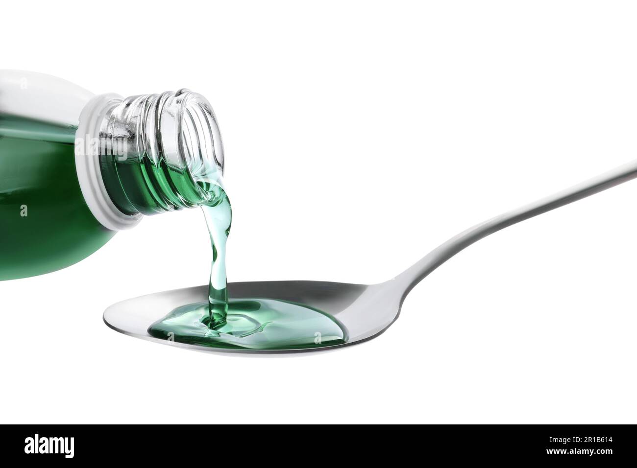 Pouring syrup into spoon from bottle isolated on white, closeup. Cough ...