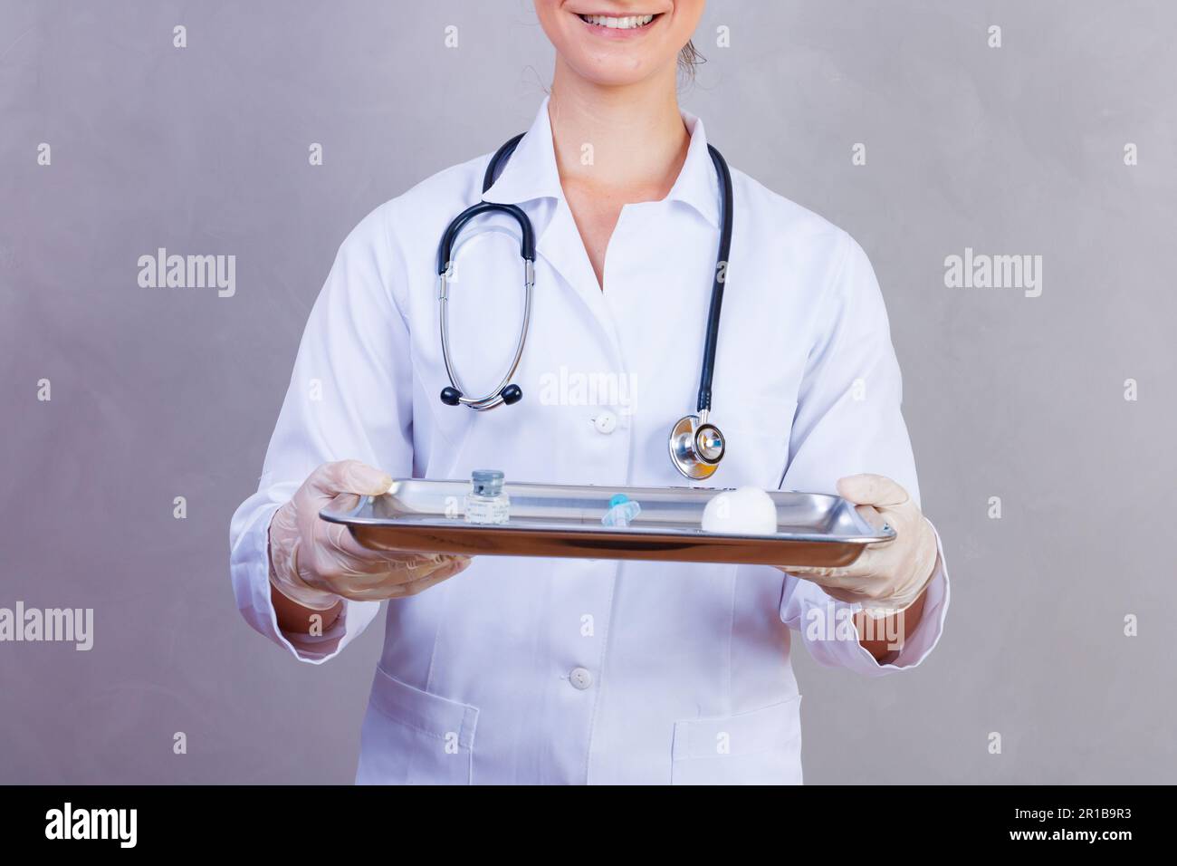 nurse holding tray with medicines on gray background. Doctors on gray background. Vaccine and ...