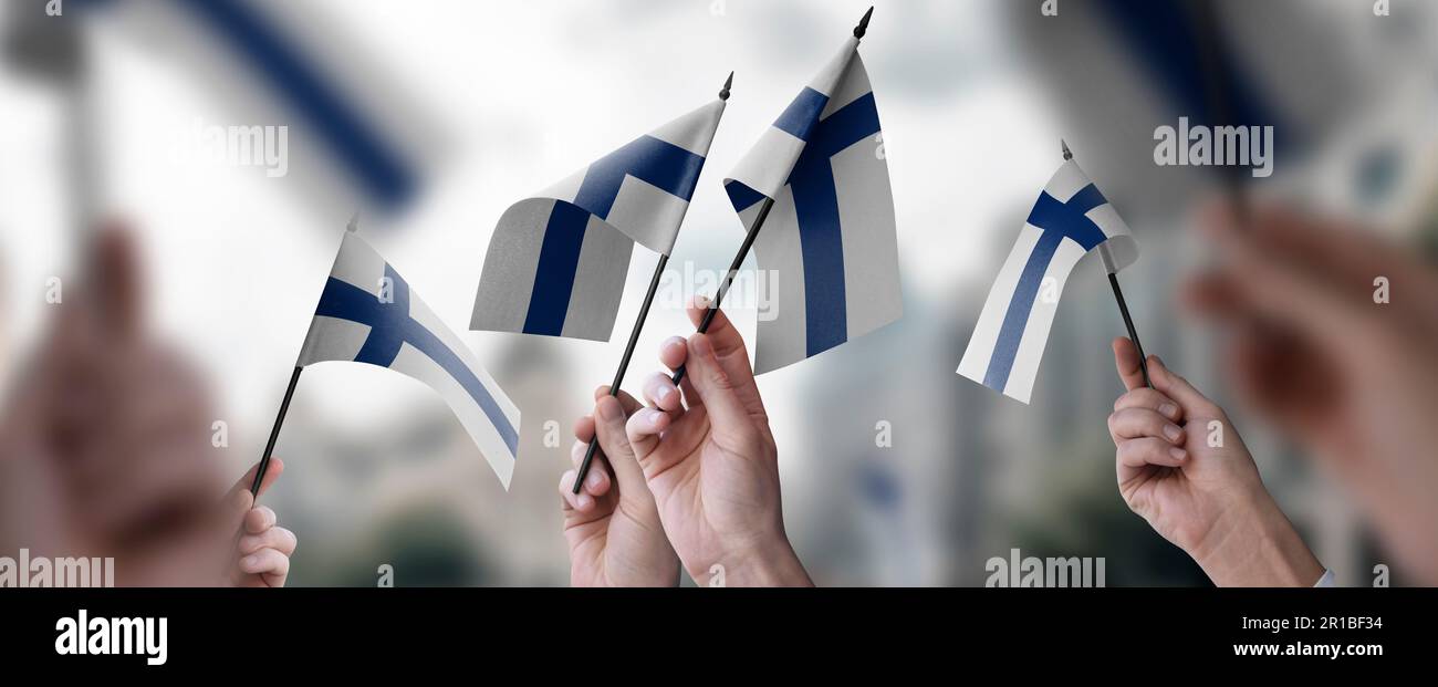 A group of people holding small flags of the Finland in their hands ...