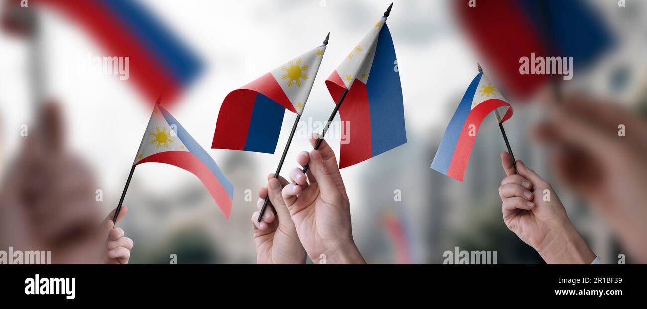 A group of people holding small flags of the Philippines in their hands ...