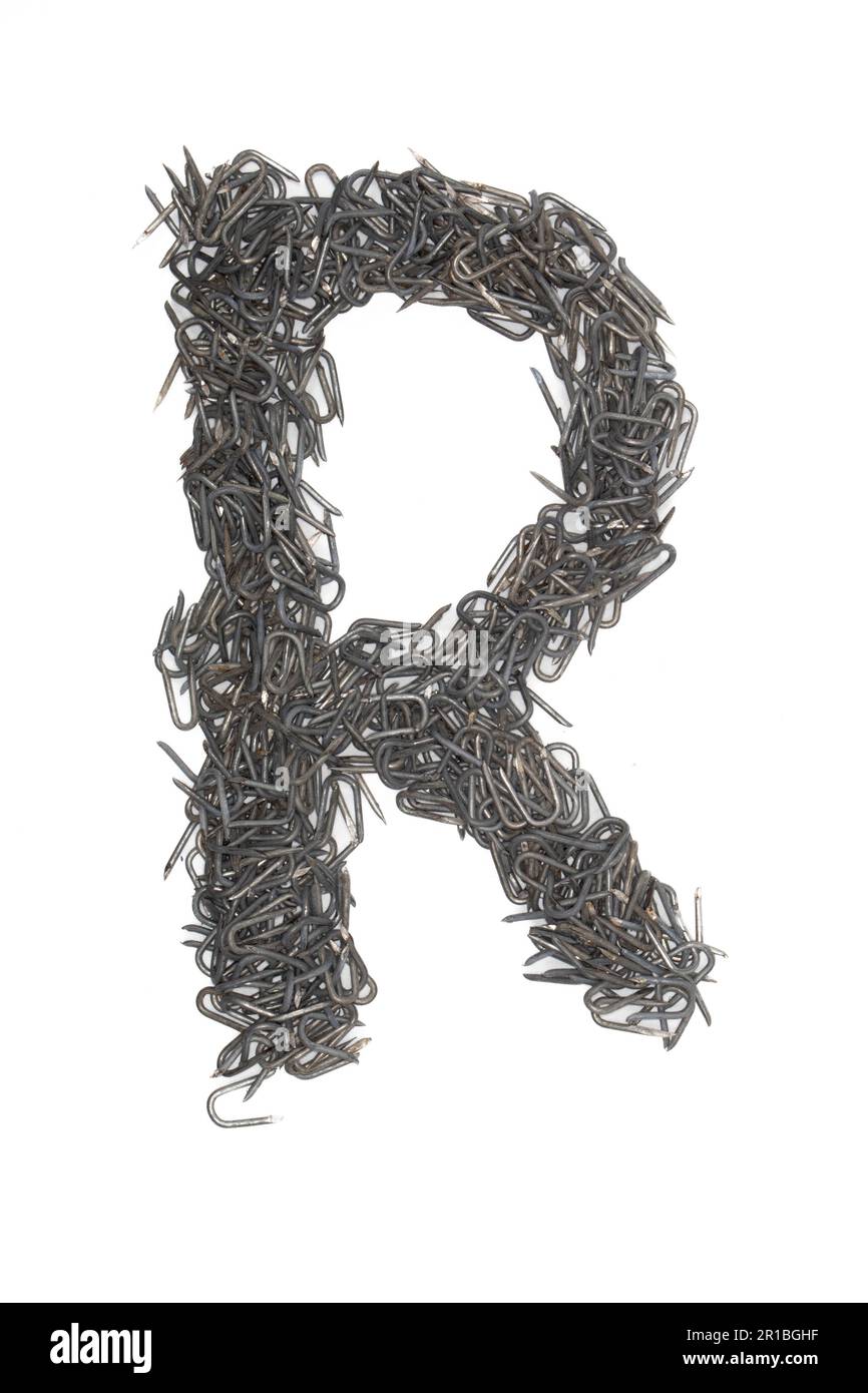artistic isolated Letter R made from steel staples isolated on a white ...