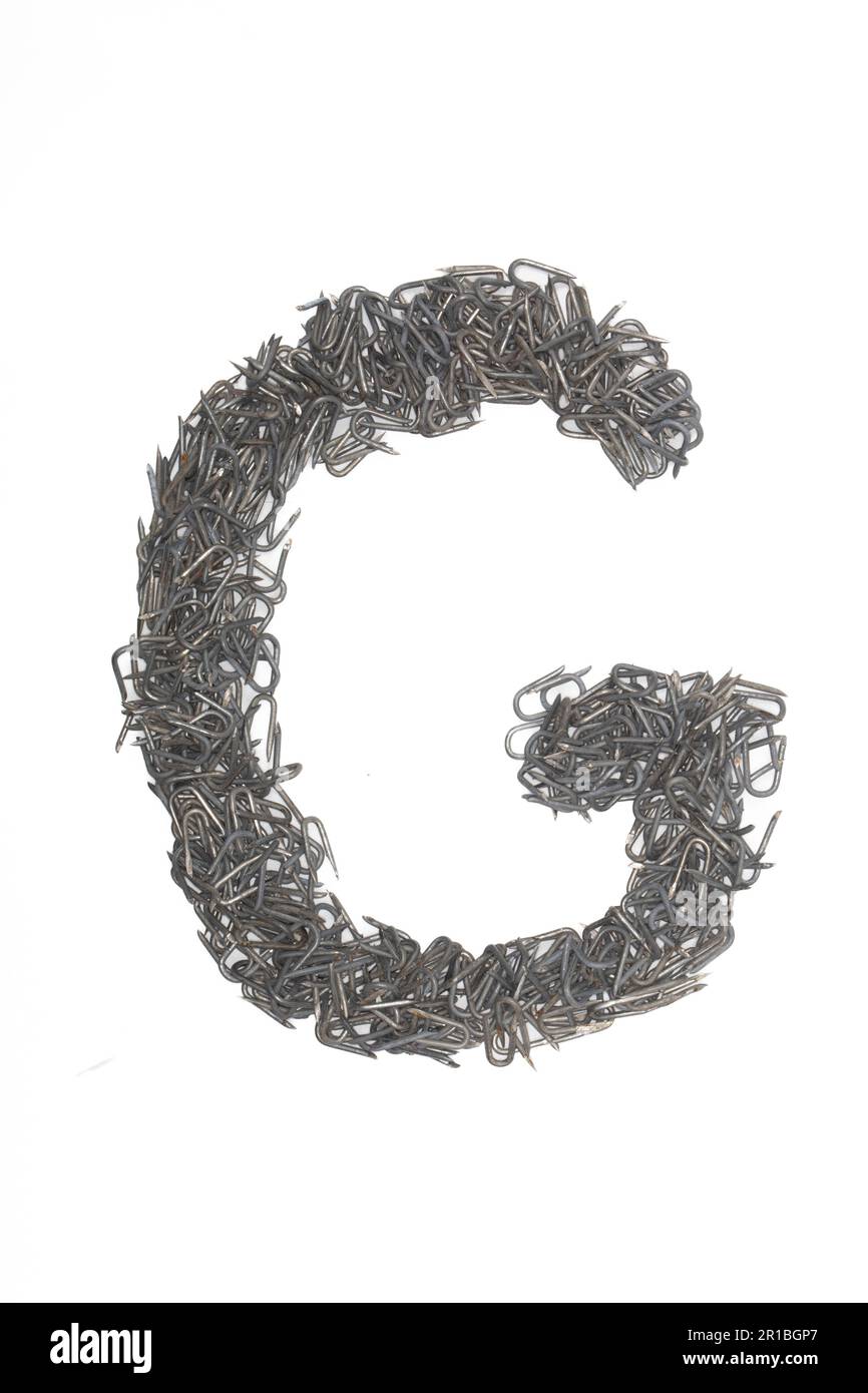artistic isolated Letter G made from steel staples isolated on a white ...