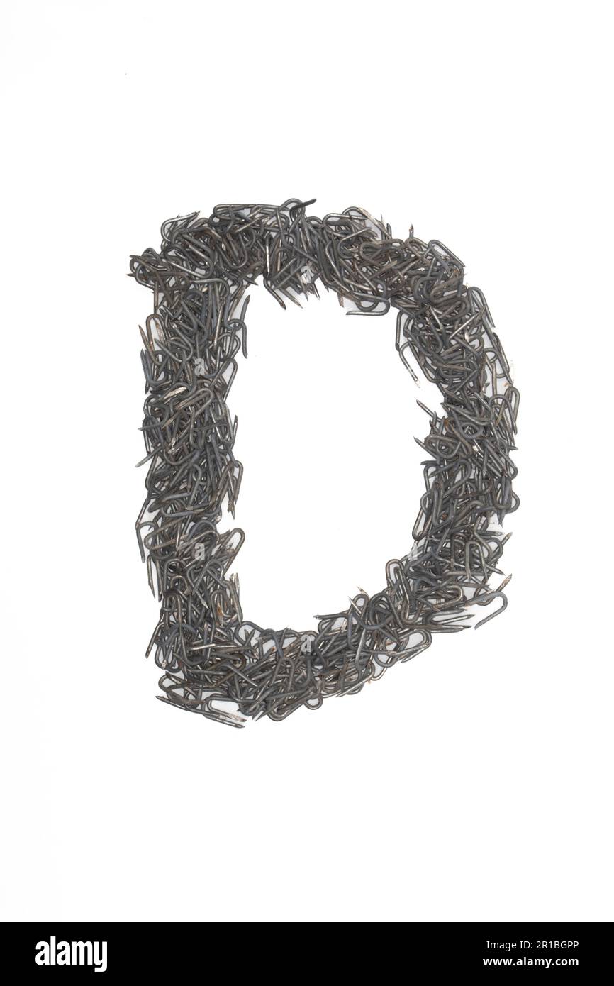 artistic isolated Letter D made from steel staples isolated on a white ...