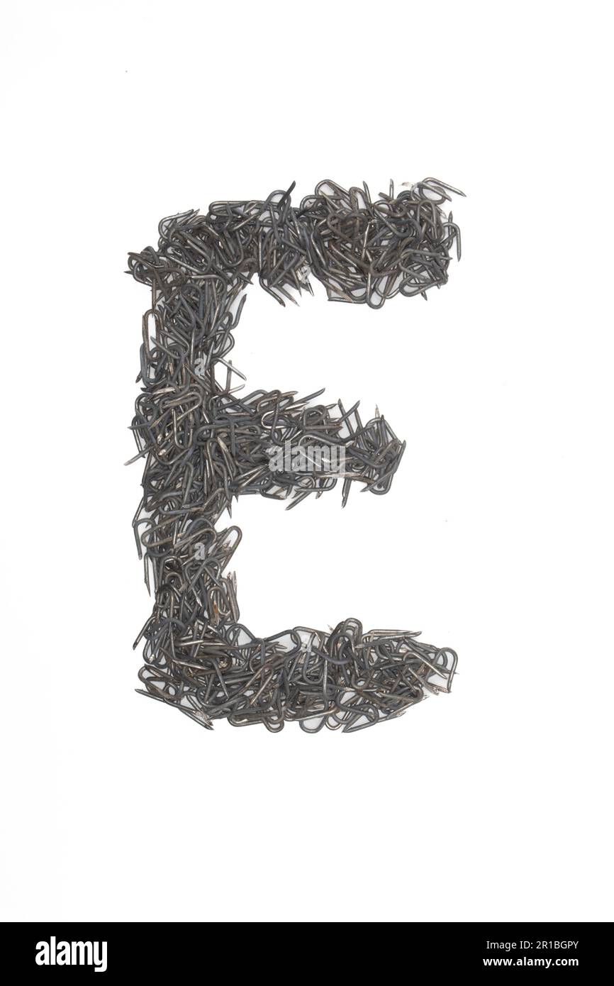 artistic isolated Letter E made from steel staples isolated on a white ...