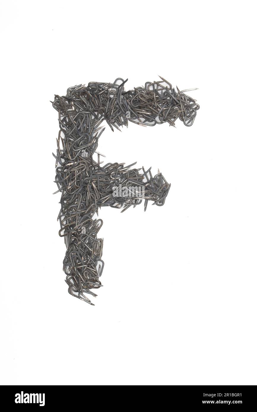 artistic isolated Letter F made from steel staples isolated on a white ...