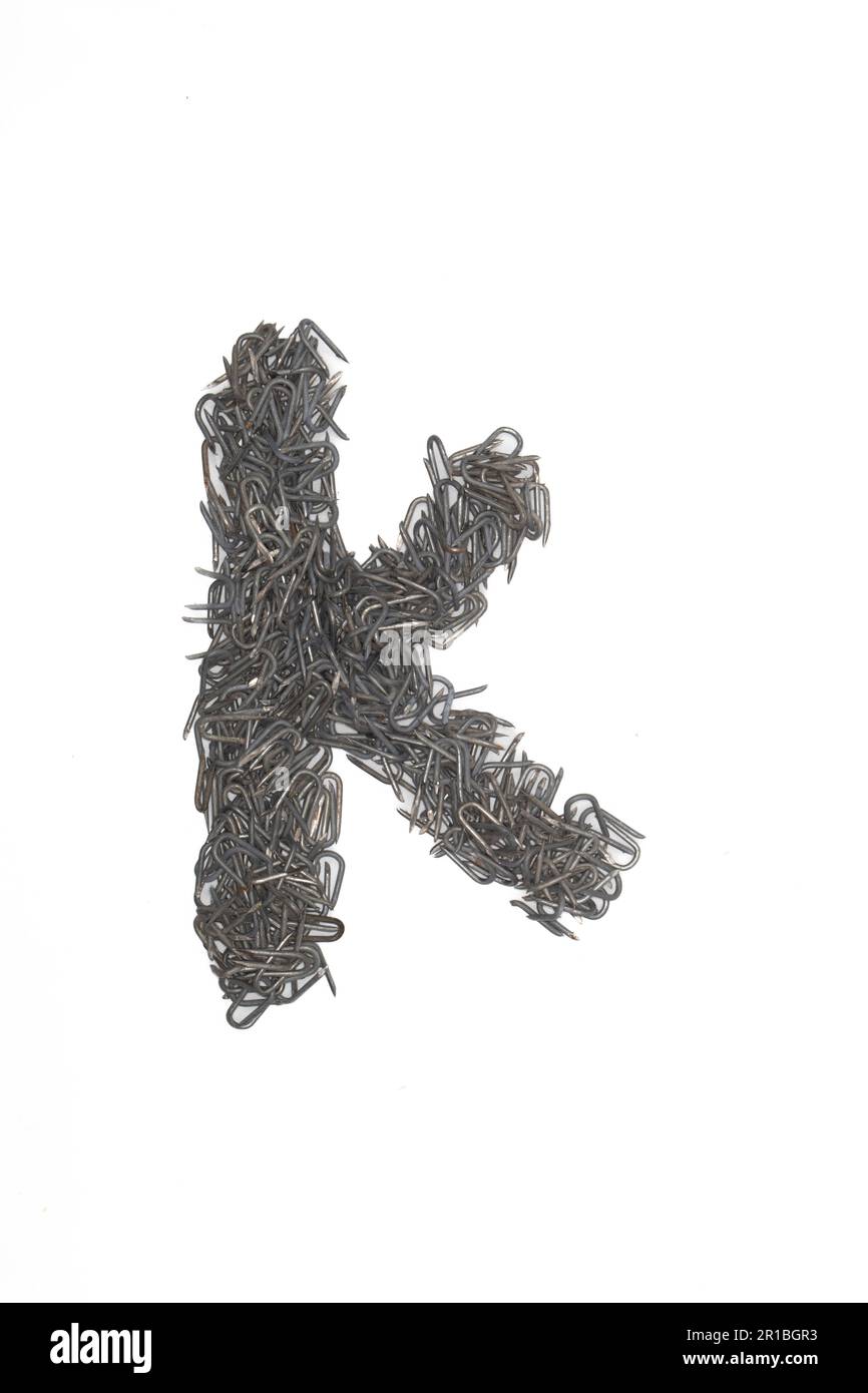 artistic isolated Letter k made from steel staples isolated on a white ...