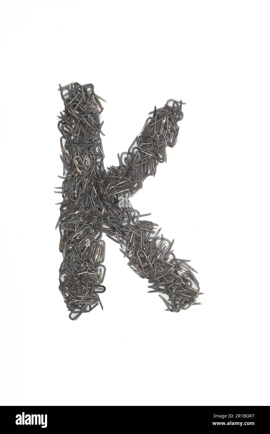 artistic isolated Letter k made from steel staples isolated on a white ...