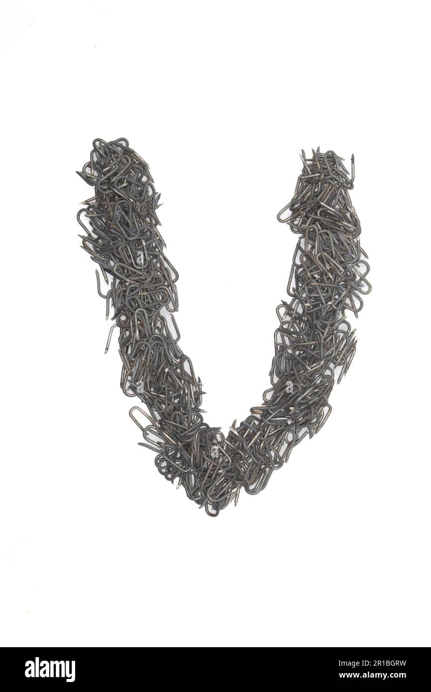 artistic isolated Letter v made from steel staples isolated on a white ...