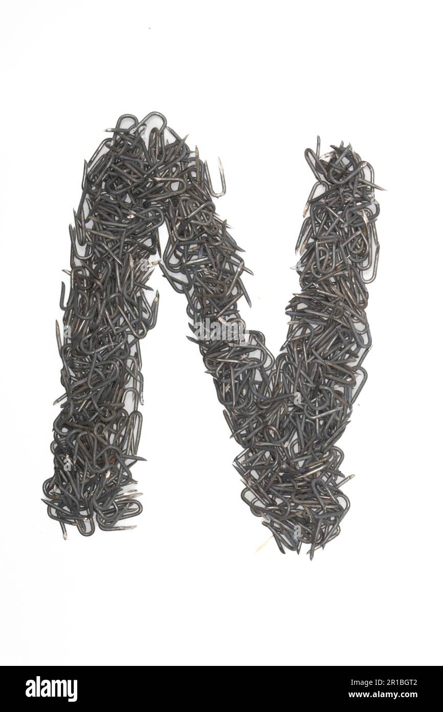 artistic isolated Letter N made from steel staples isolated on a white ...