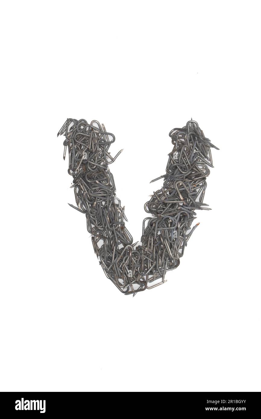 artistic isolated Letter v made from steel staples isolated on a white ...