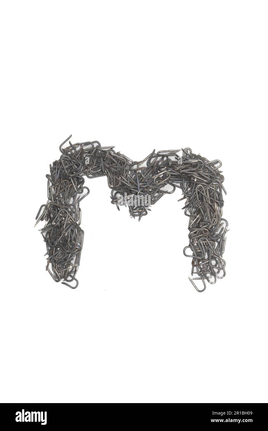 artistic isolated Letter m made from steel staples isolated on a white ...