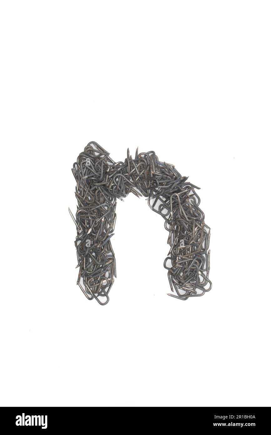 artistic isolated Letter n made from steel staples isolated on a white ...