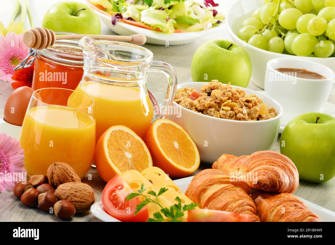 Breakfast consisting of fruits, orange juice, coffee, honey, bread and ...