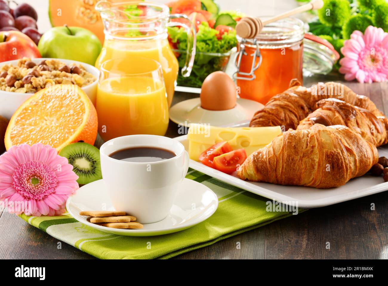 Breakfast consisting of fruits, orange juice, coffee, honey, bread and ...
