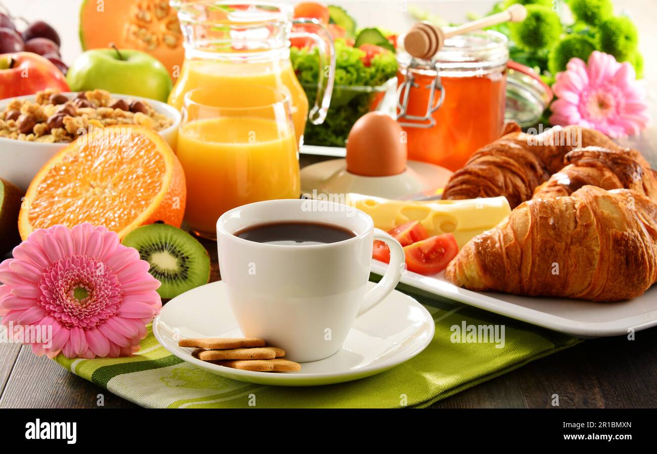 Breakfast consisting of fruits, orange juice, coffee, honey, bread and ...