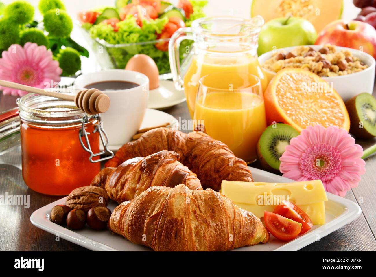Breakfast consisting of fruits, orange juice, coffee, honey, bread and ...