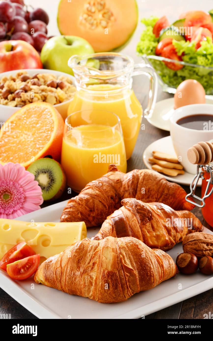Breakfast consisting of fruits, orange juice, coffee, honey, bread and ...