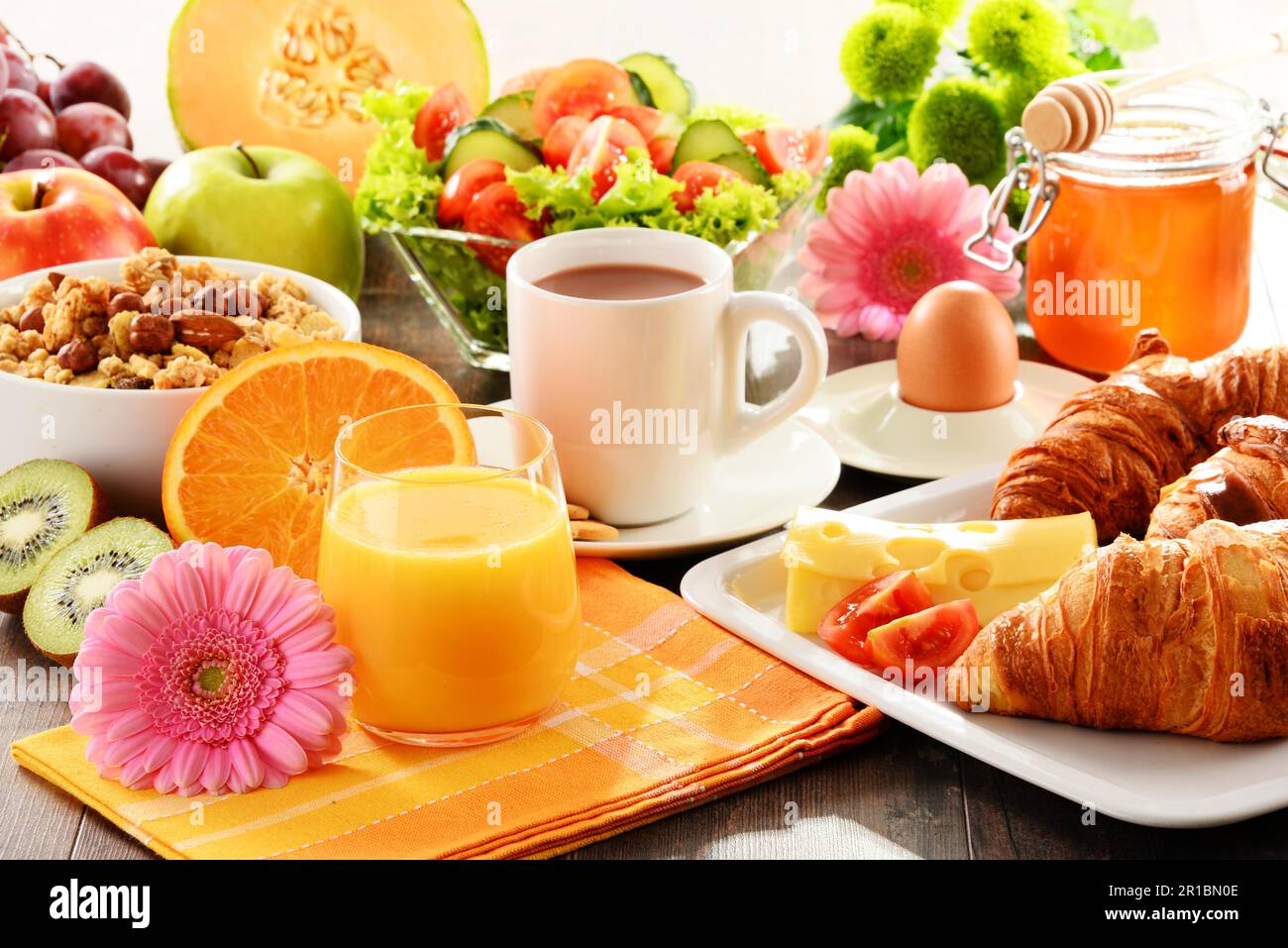 Breakfast consisting of fruits, orange juice, coffee, honey, bread and ...
