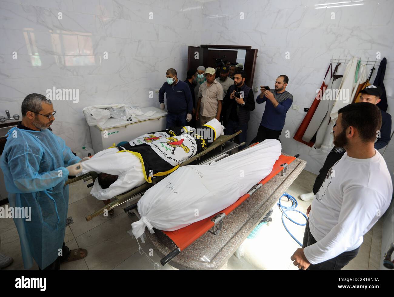 Gaza, Palestine. 11th May, 2023. Palestinians stand next to the body of ...