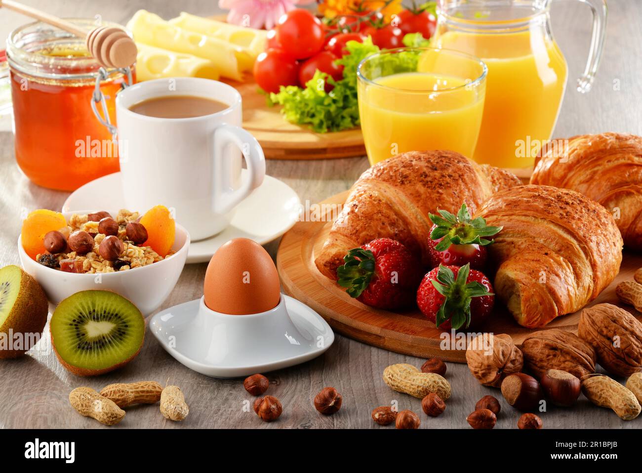 Breakfast consisting of croissants, coffee, fruits, orange juice ...