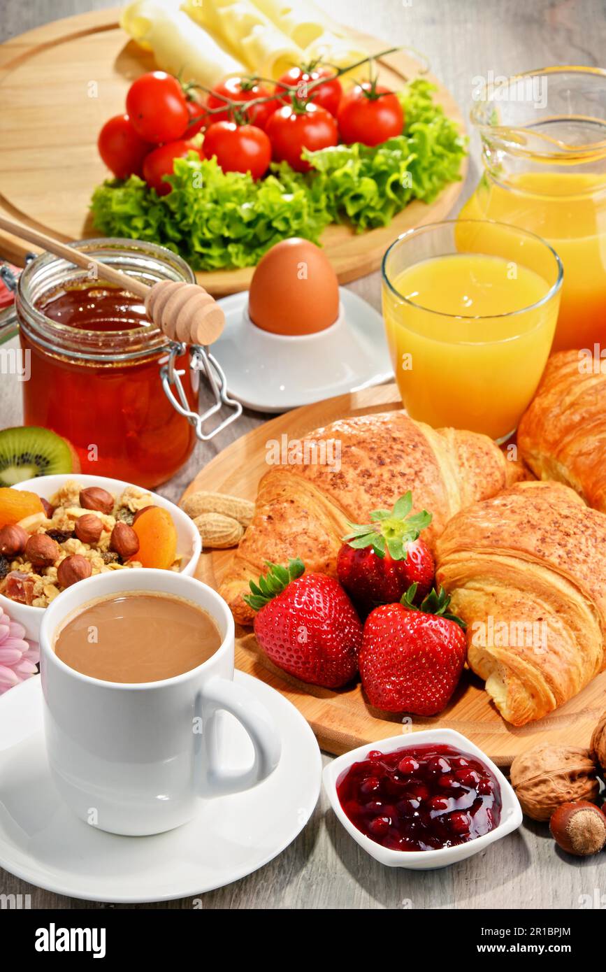 Breakfast consisting of croissants, coffee, fruits, orange juice, coffee and jam. Balanced diet ...