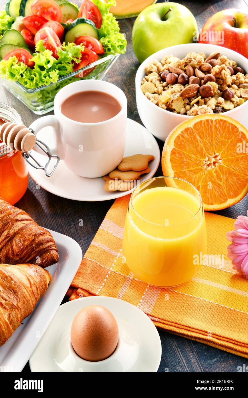 Breakfast consisting of fruits, orange juice, coffee, honey, bread and ...