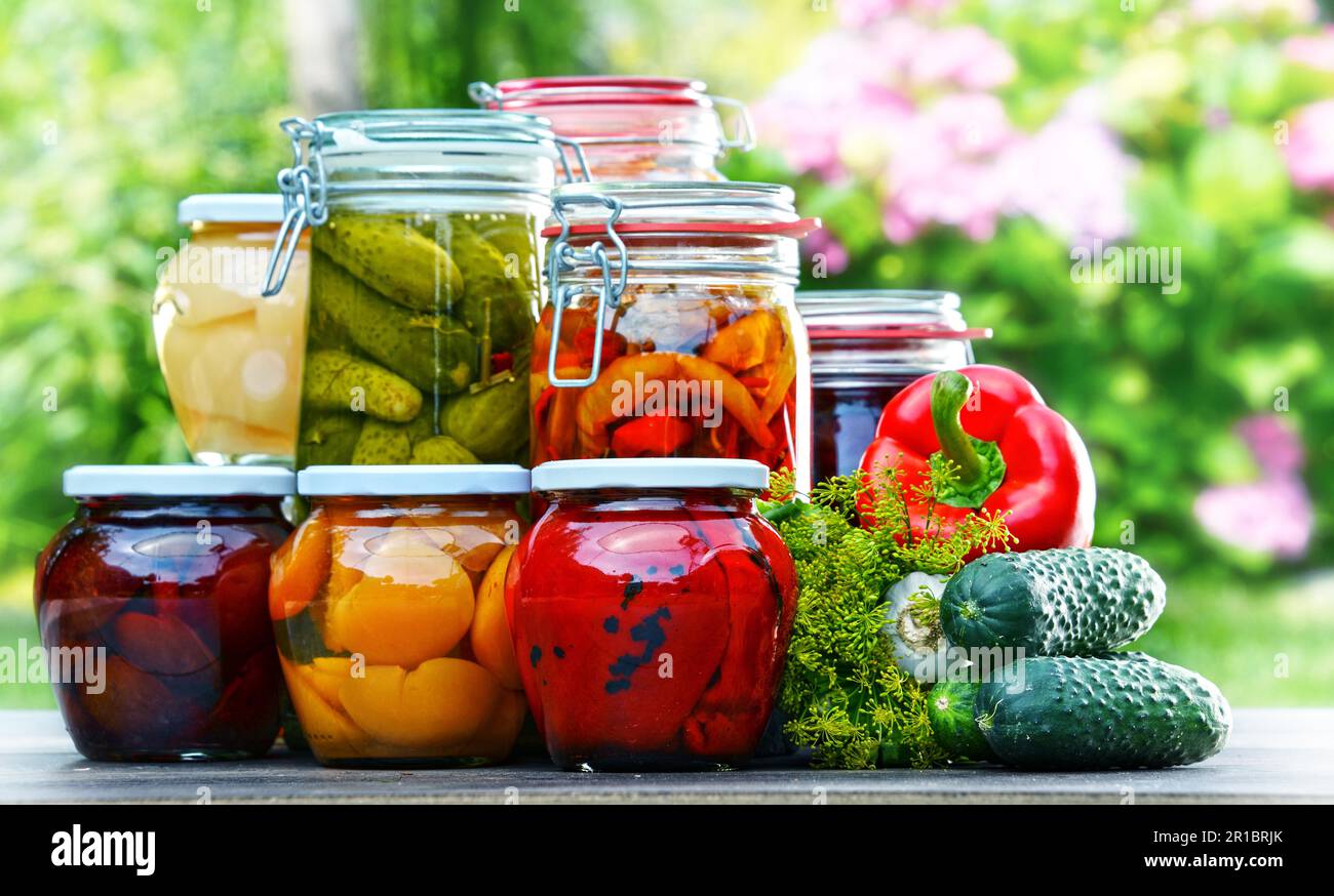 Jars of pickled vegetables and fruits in the garden. Marinated food ...